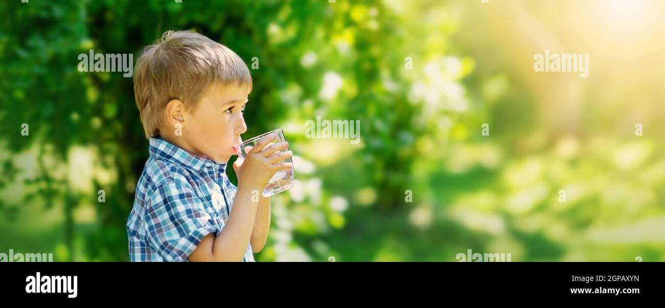 Cute boy drinking a glass of pure water in nature. Concept of the ...