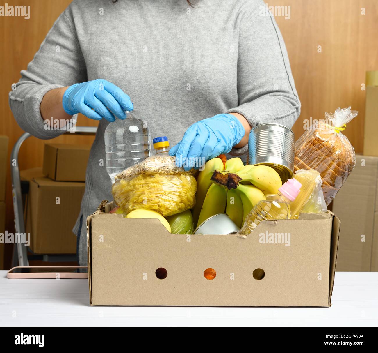 woman in gloves keeps collecting food, fruits and things and a ...