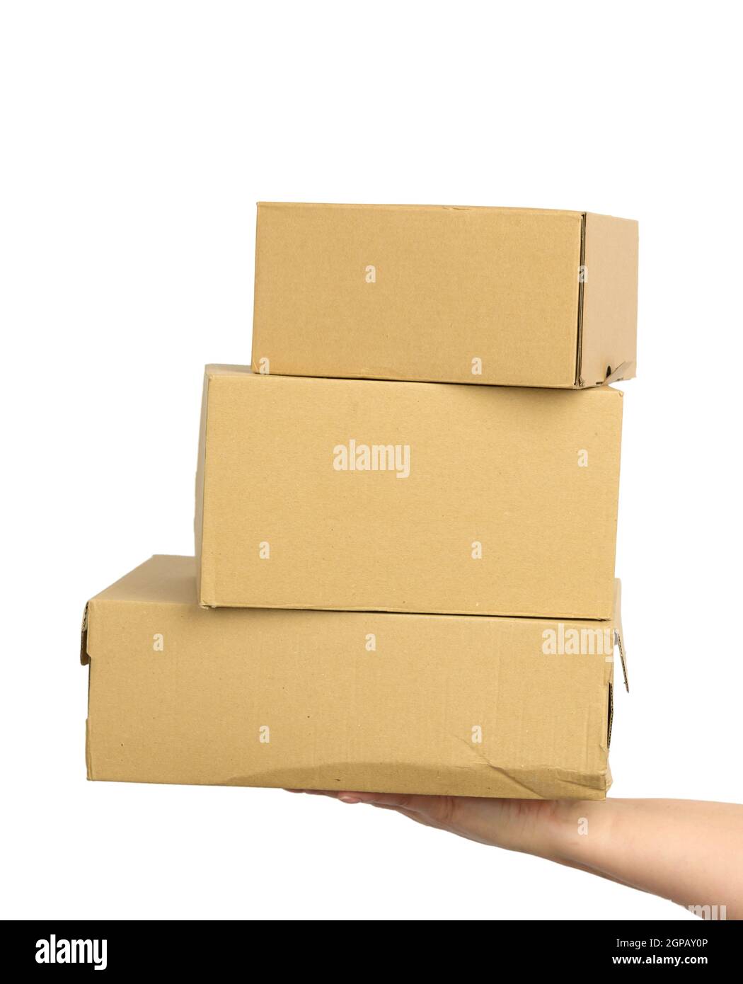 hand holds a brown cardboard box of paper on a white isolated ...