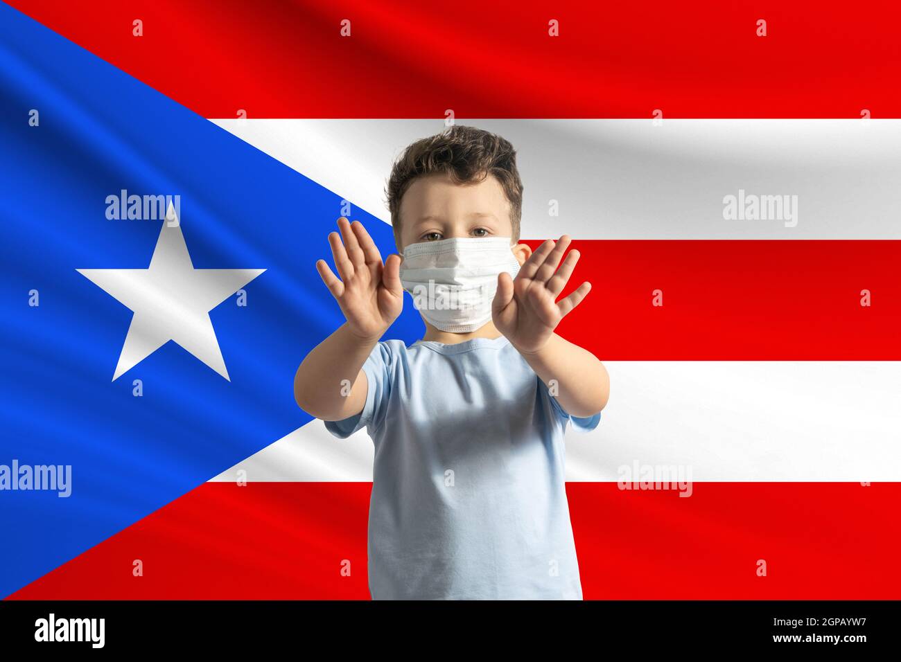 Little White Boy In A Protective Mask On The Background Of The Flag Of Puerto Rico Makes A Stop little-white-boy-in-a-protective-mask-on-the-background-of-the-flag-of-puerto-rico-makes-a-stop