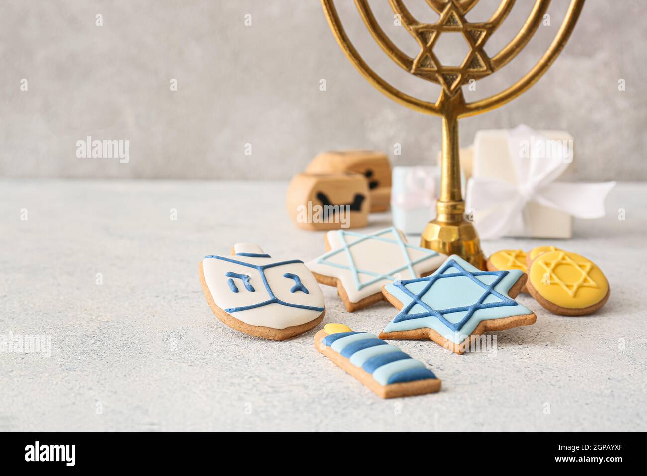 Tasty cookies for Hanukkah celebration with menorah on grey background ...