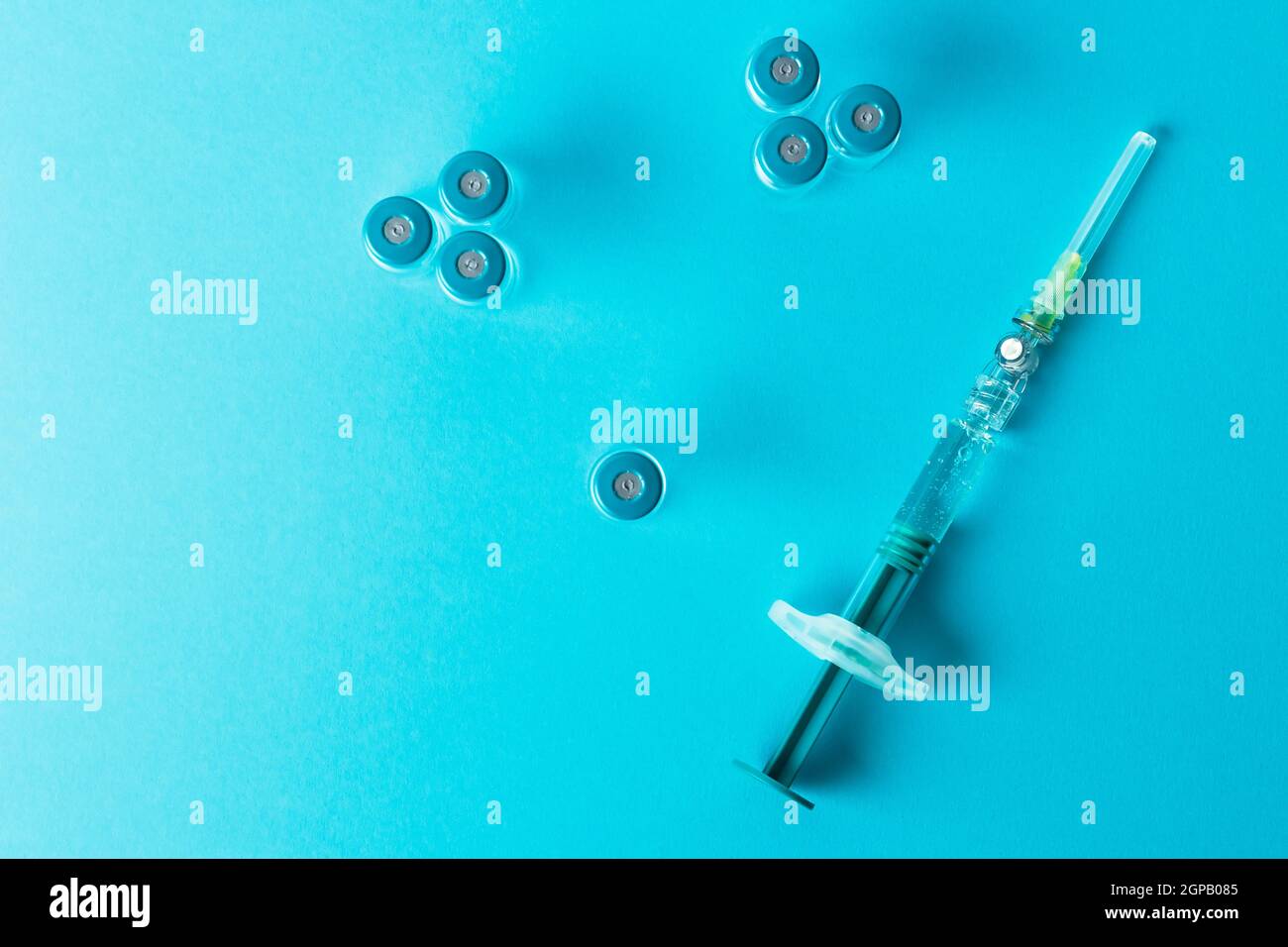 Syringe with several medical vials for injection on blue background ...