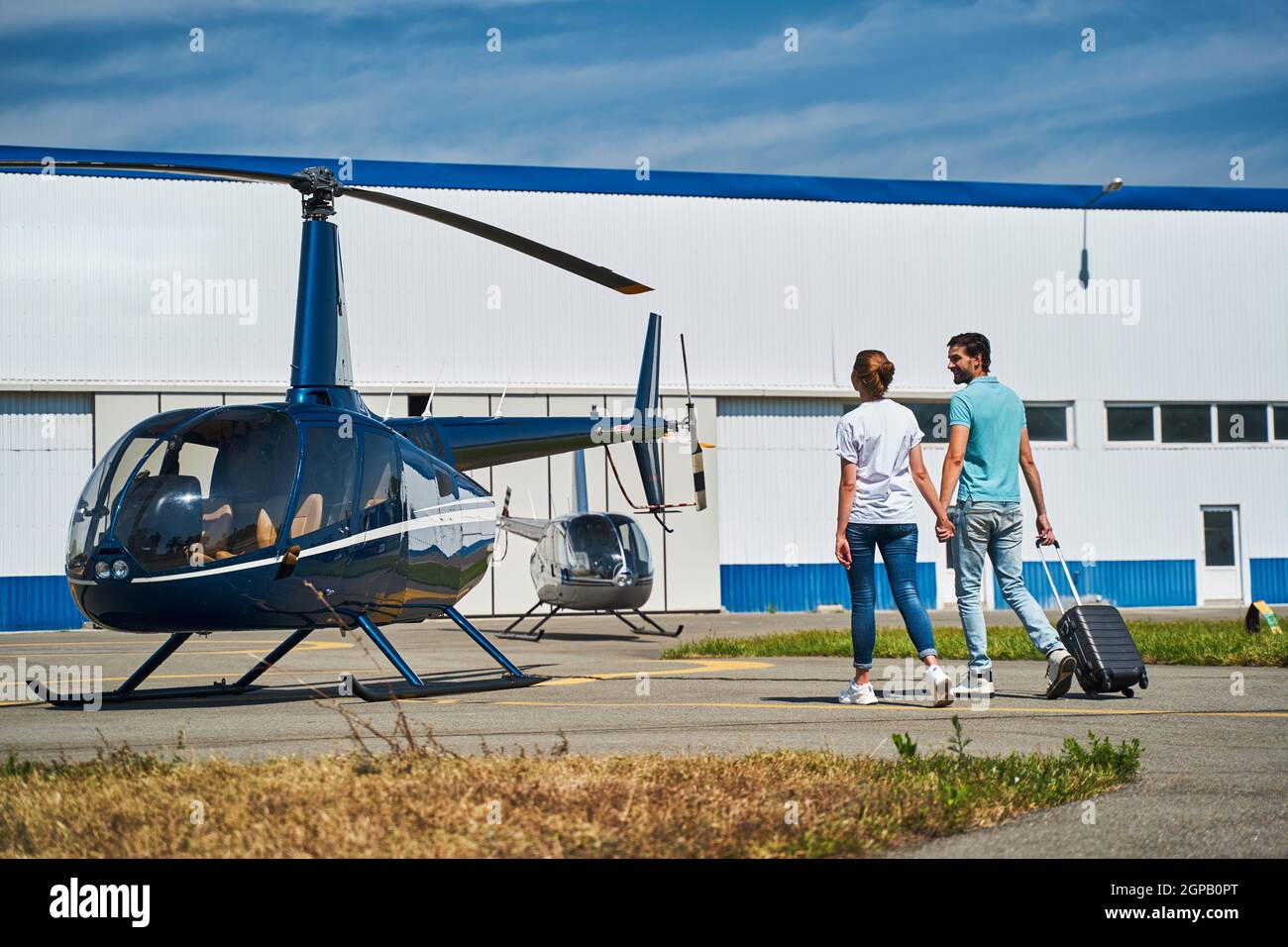 Romantic tourist couple moving towards landed helicopter Stock Photo ...