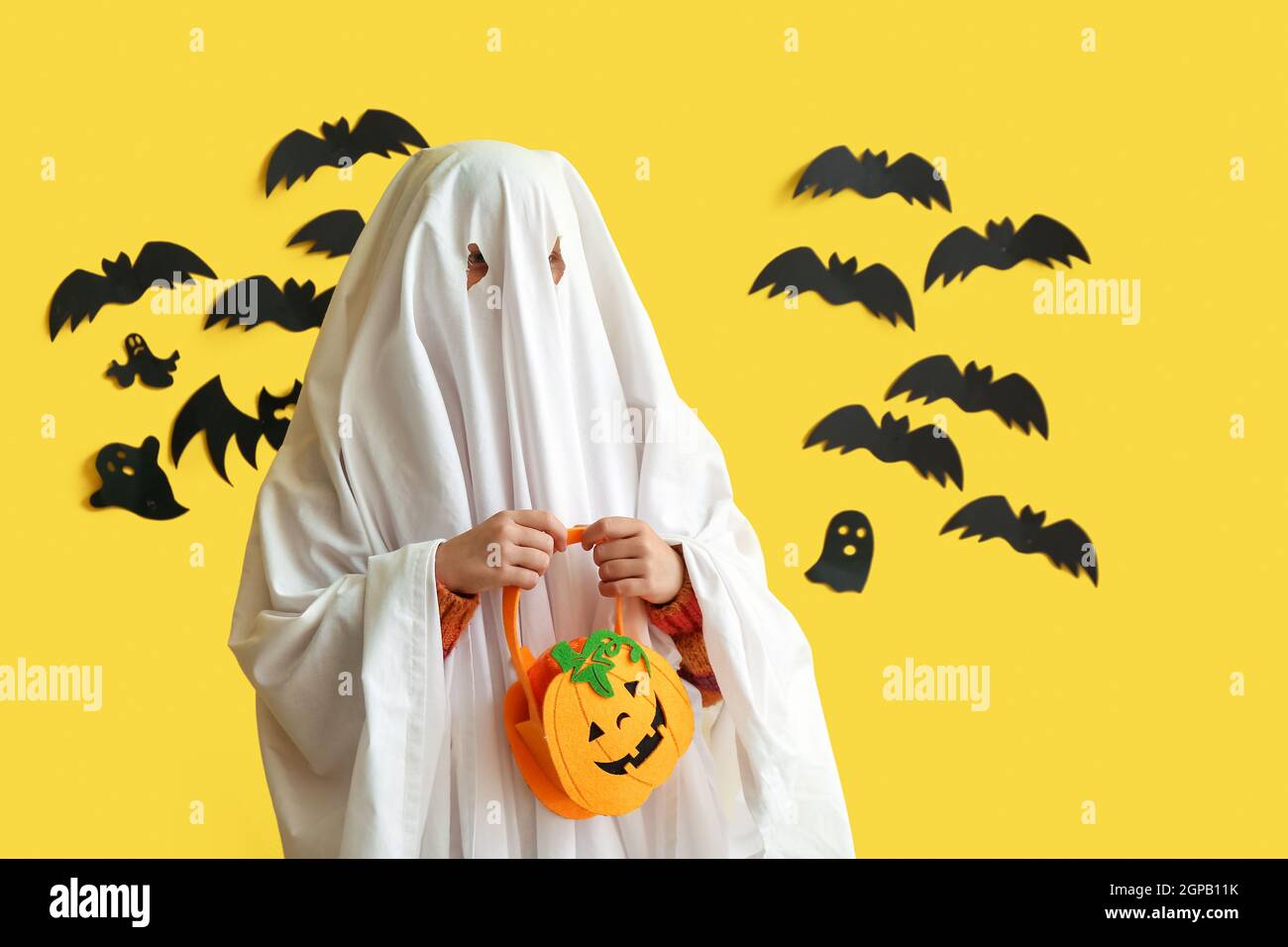 Cute little child in Halloween costume of ghost on color background ...