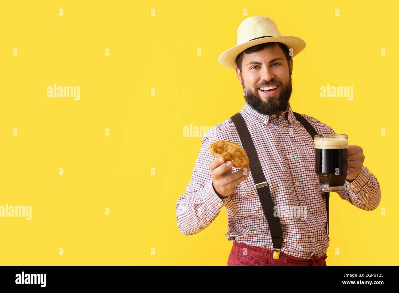 Handsome man in traditional German clothes, with beer and pretzel on ...