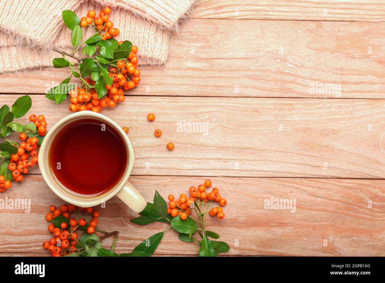 Cup of hot tea and rowan berries on wooden background Stock Photo - Alamy