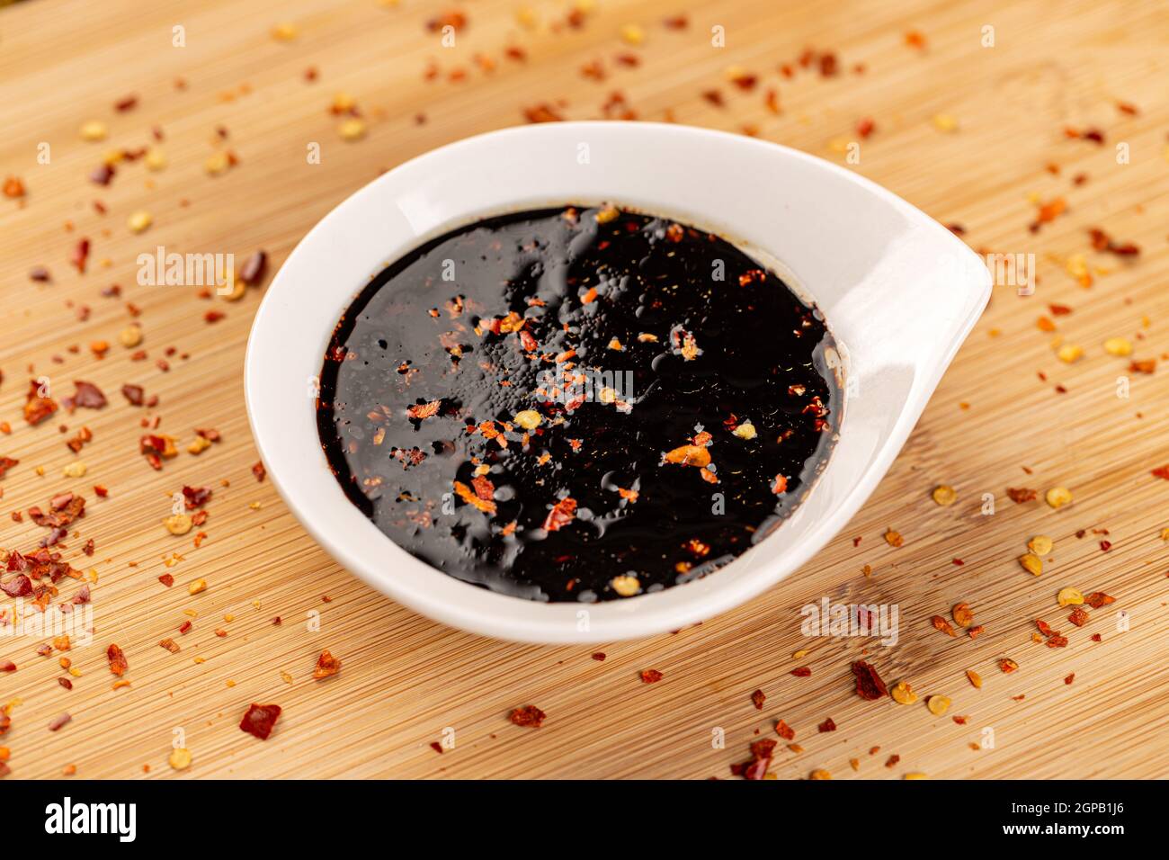Bowl of teriyaki sauce, traditional Japanese sauce on bamboo board ...