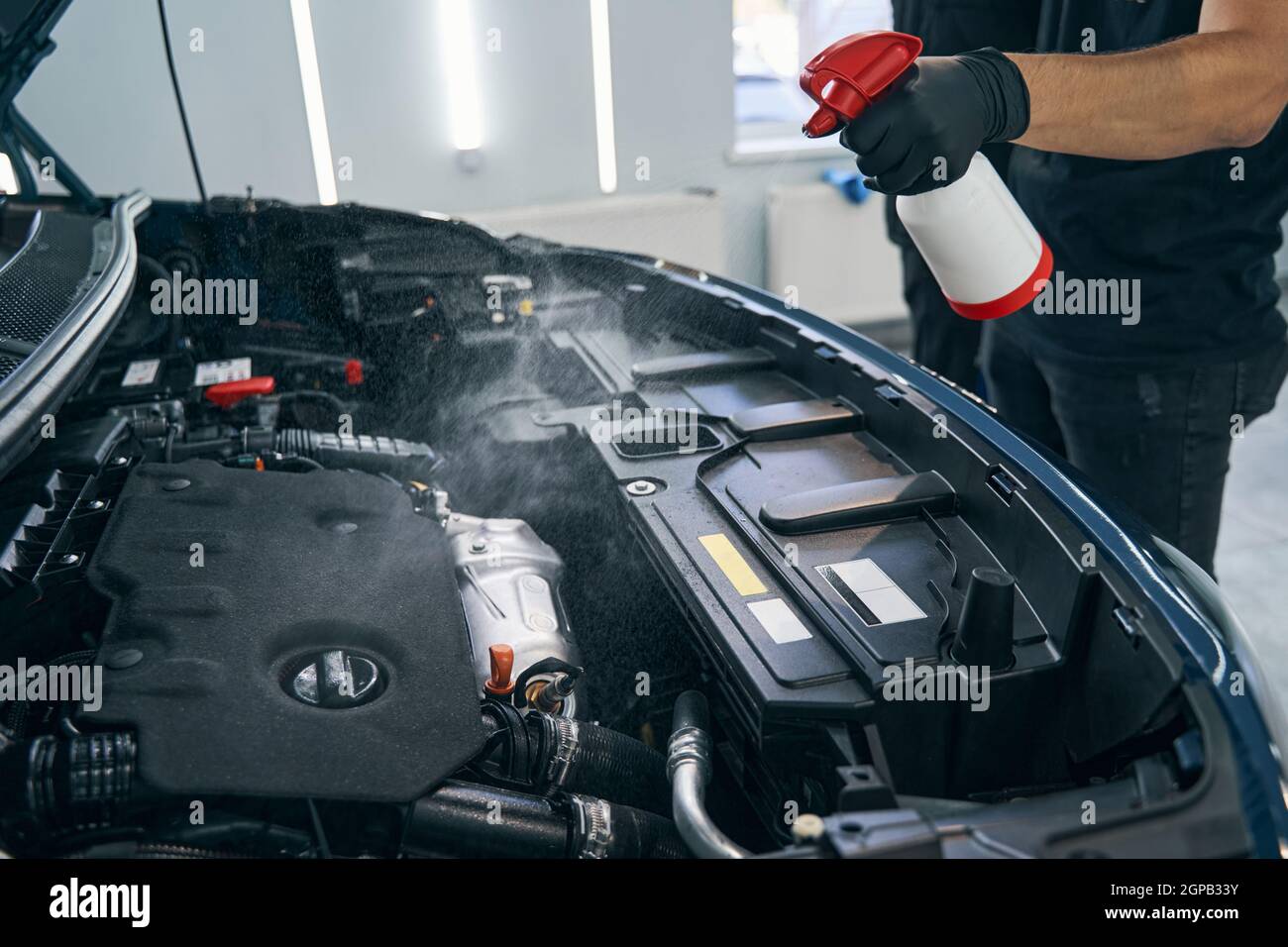 Cleaning car engine with foam spray by serviceman. Dry auto washing ...