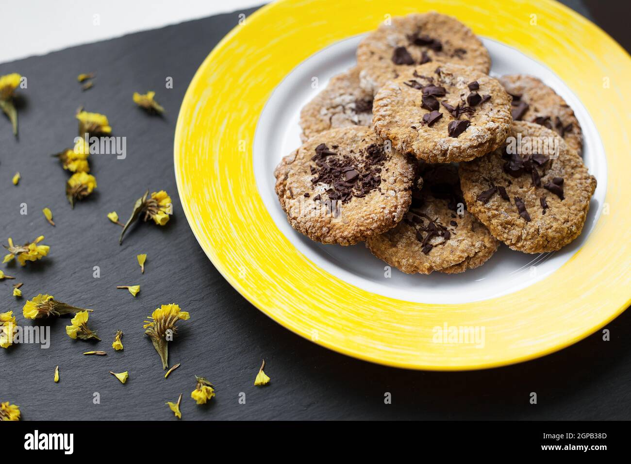 Oatmeal cookies with chocolate on bright yellow plate Stock Photo - Alamy