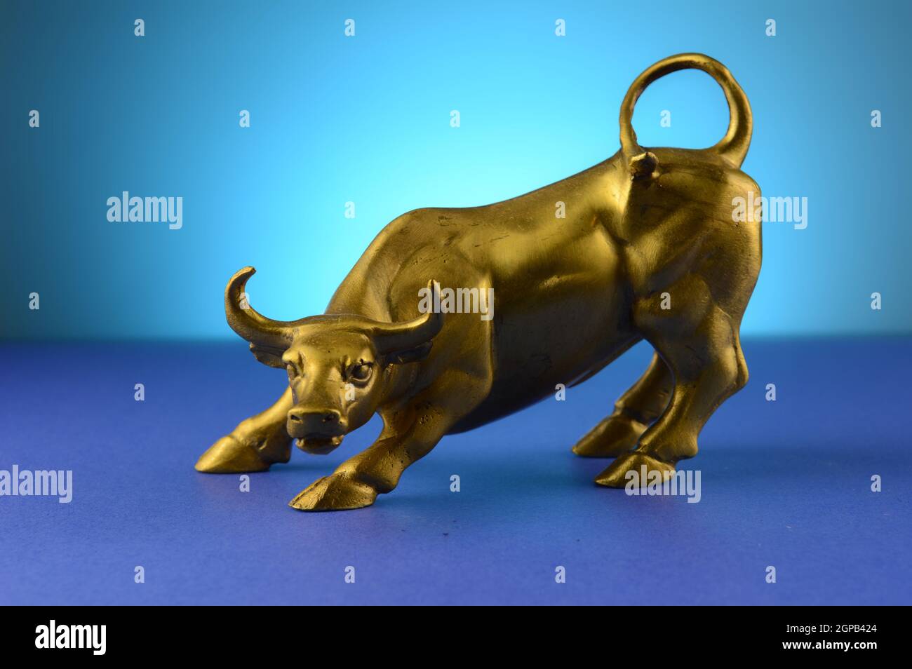 A brass bull figure over a blue gradient background to represent the ...