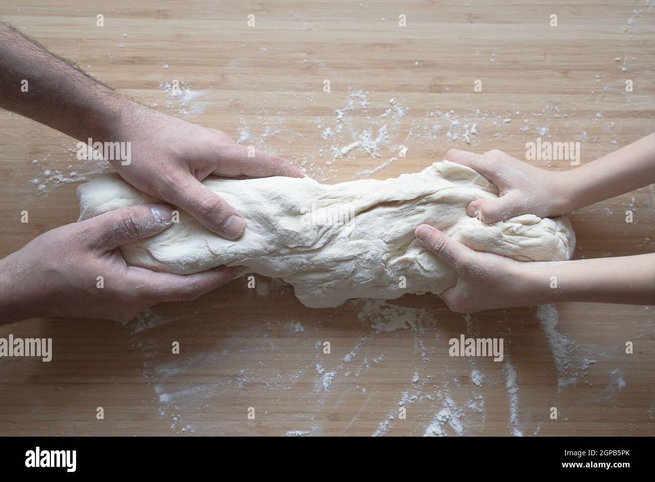 side view close up portrait of Caucasian child hands working the dough ...