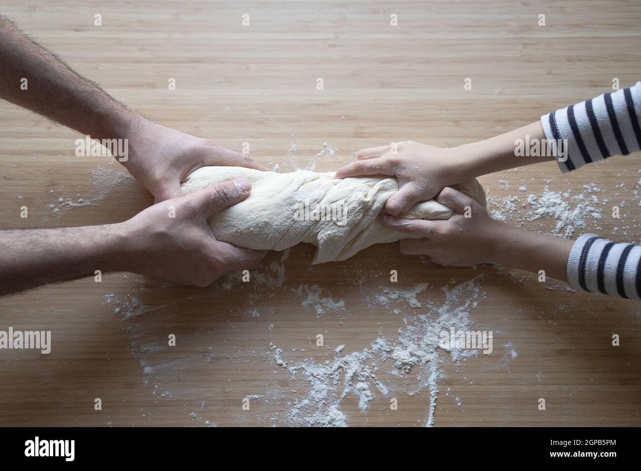 side view close up portrait of Caucasian child hands working the dough ...