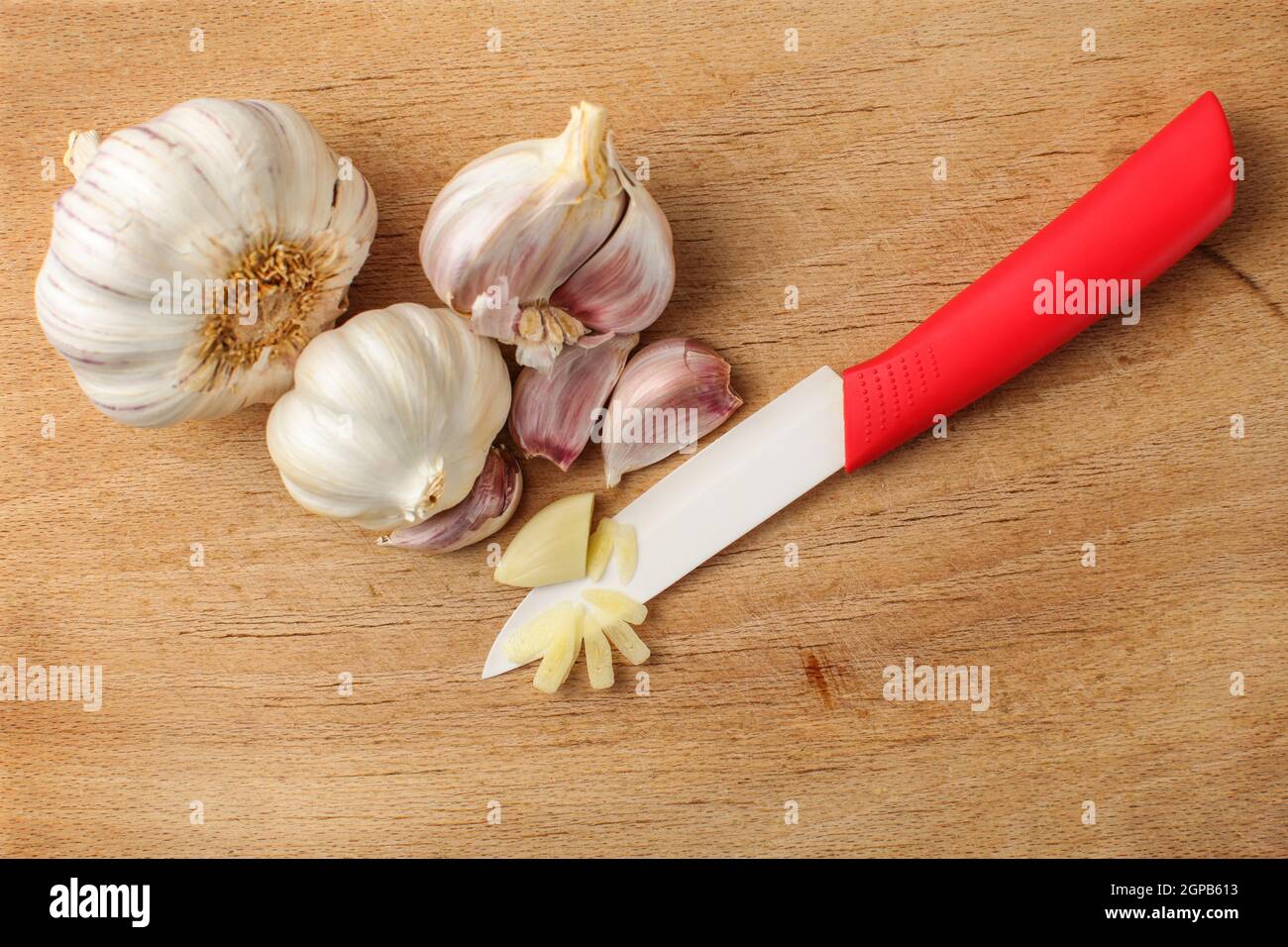 Top view of garlic bulb and cloves, one cut into small pieces with red ...
