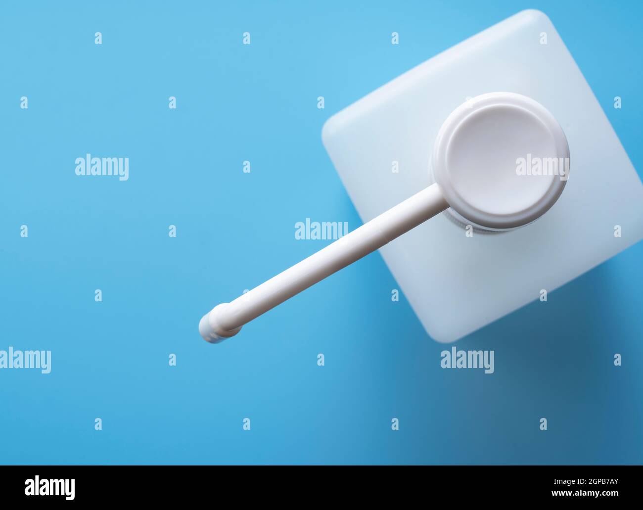 Bottle of alcohol sanitizer spray placed on a blue background in copy ...