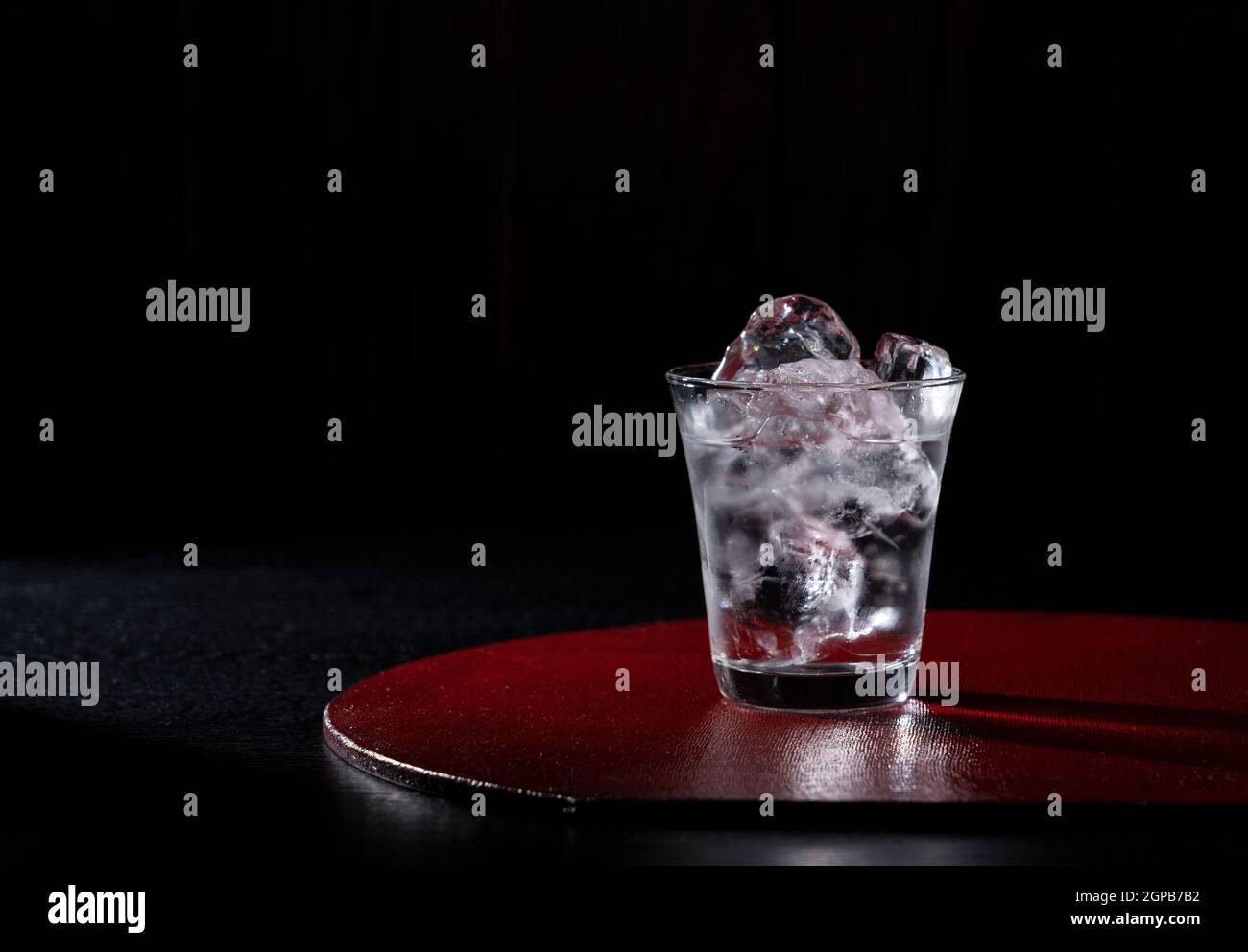 Shochu on a red tray on a black background with copy space. The image ...