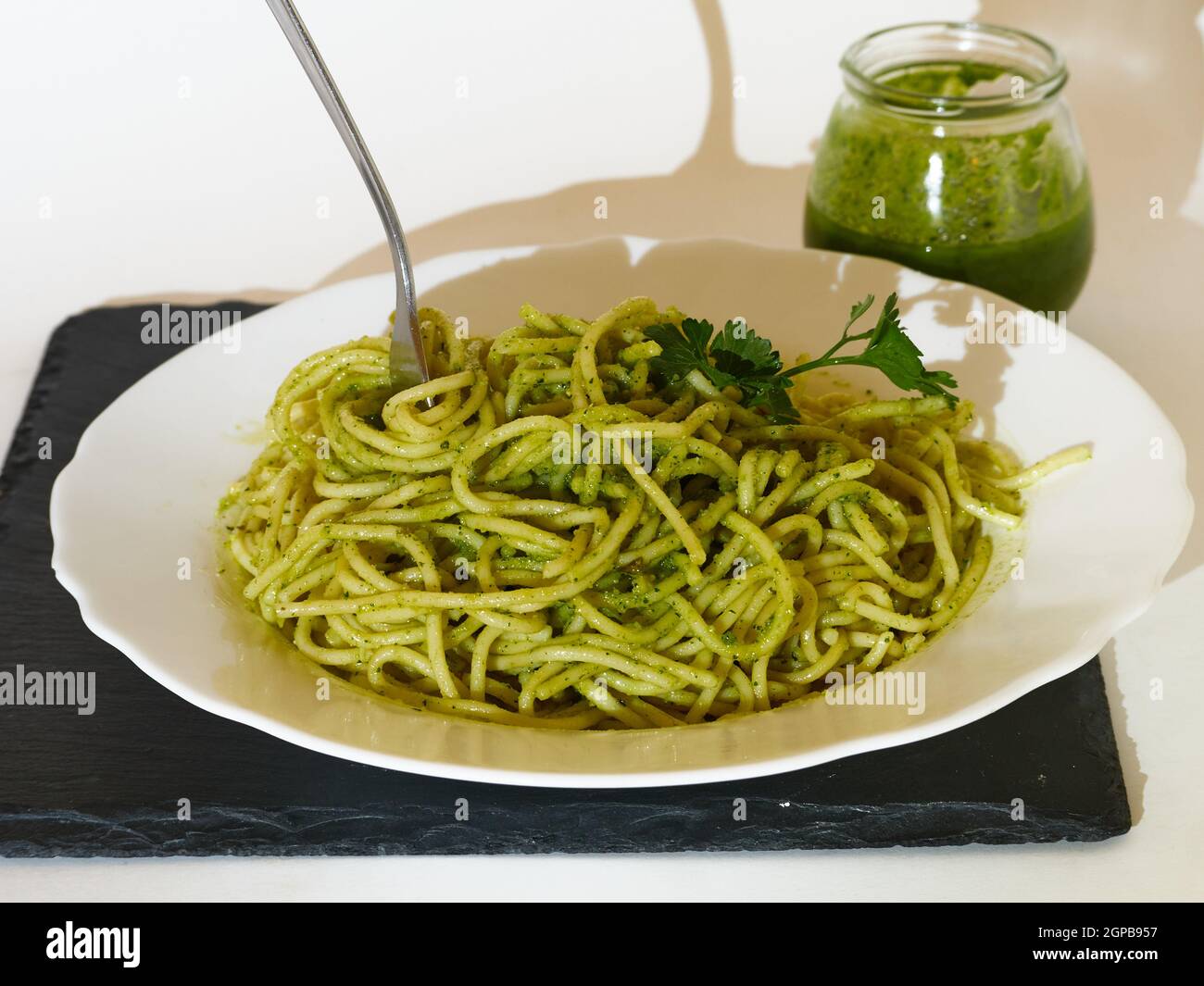 Spaghetti with homemade pesto sauce and a parsley leaf in a plate and a ...