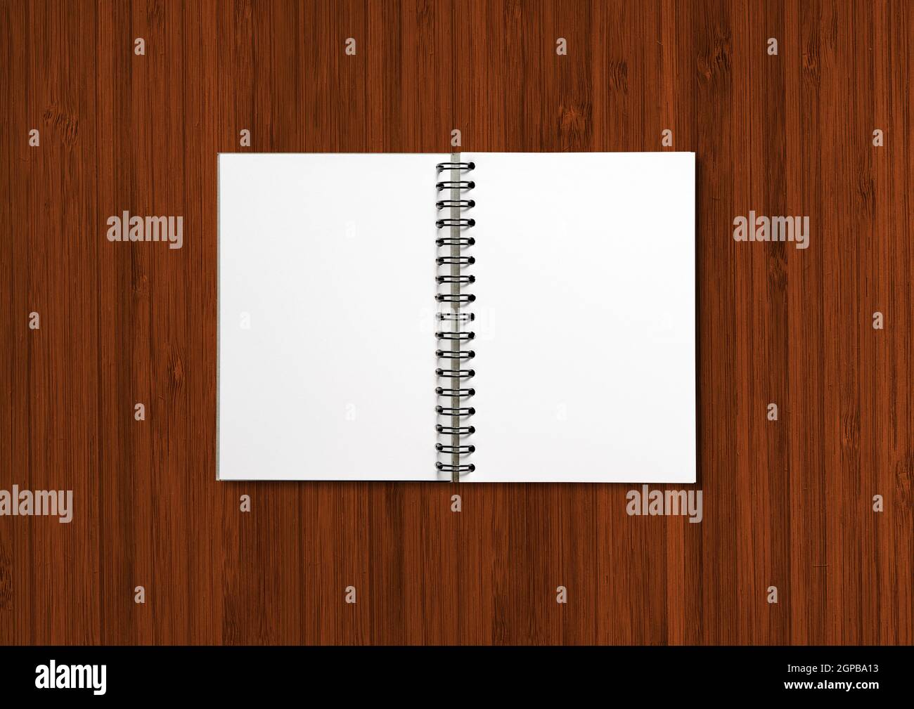 Blank open spiral notebook mockup isolated on dark wood background ...