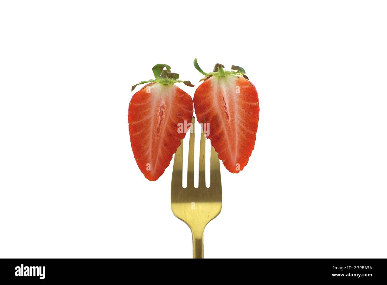 Two halves of a half-cut strawberry pinned on a golden fork isolated on ...