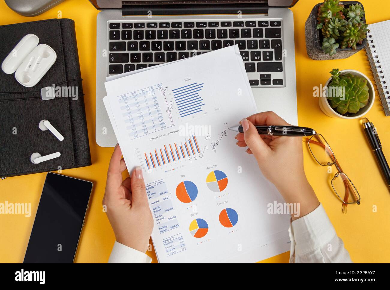 Modern office yellow desk and business woman hands writing on report ...