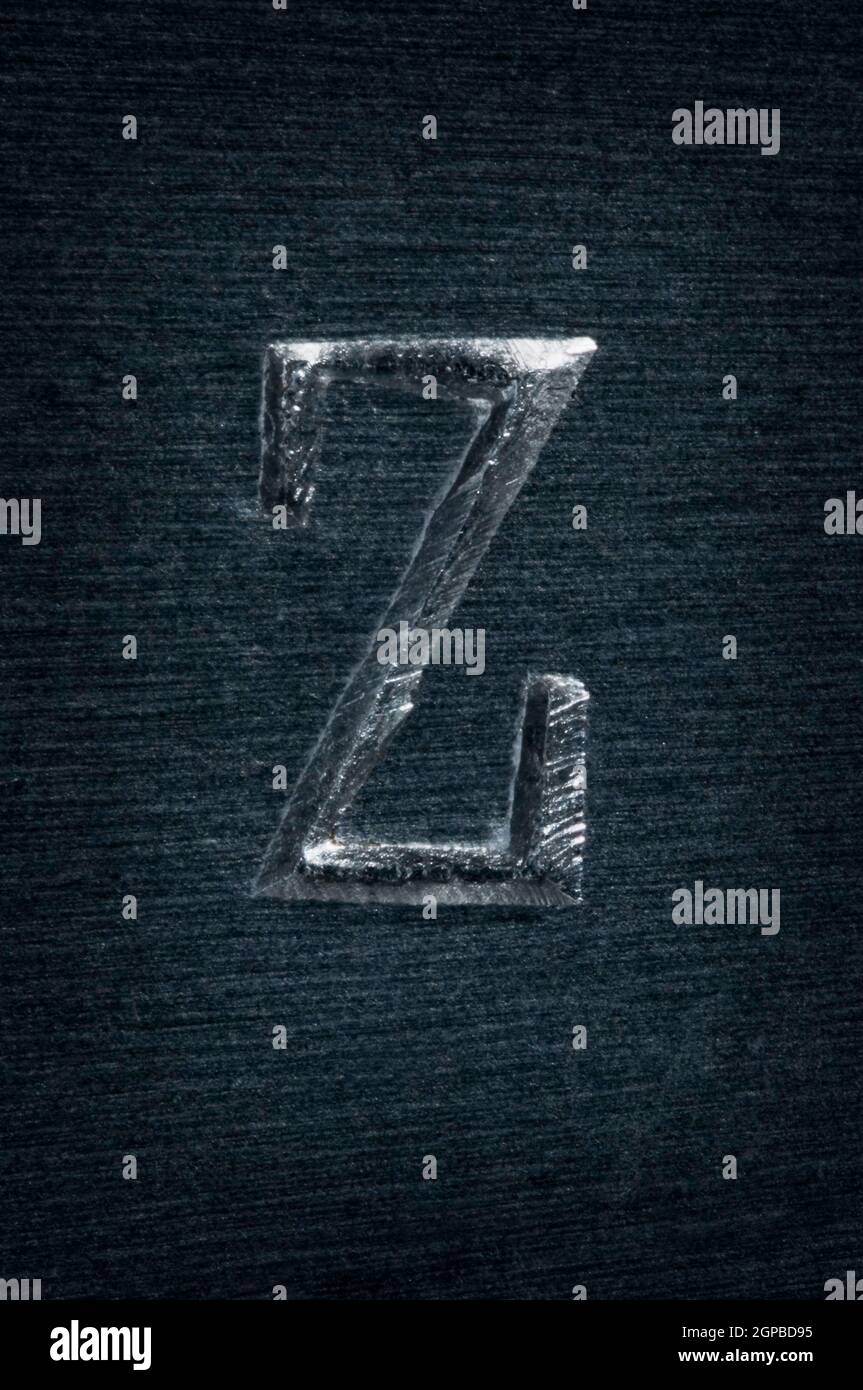 Detail view of the letter Z embossed into a gray and sanded steel plate ...