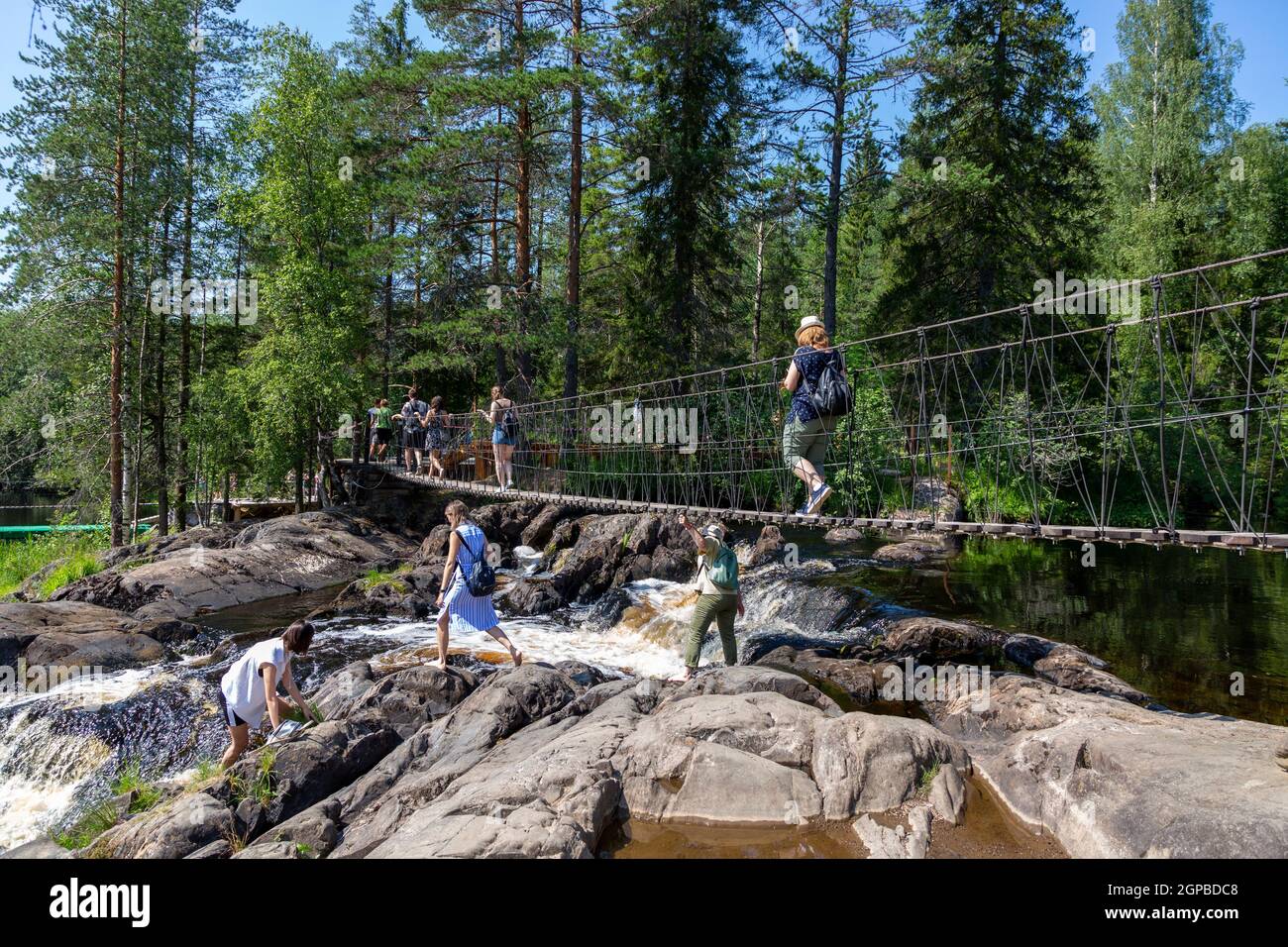 Ruskeala, Russia - July 10, 2021: People cross the suspension bridge ...