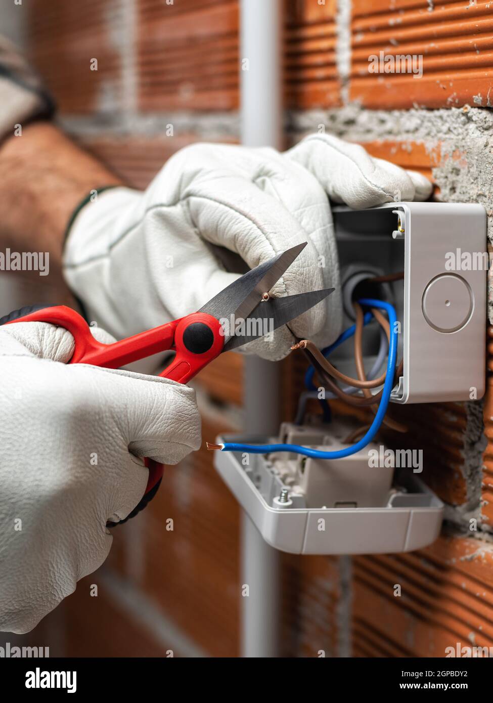 Electrician worker at work with scissors prepares electrical cables of ...