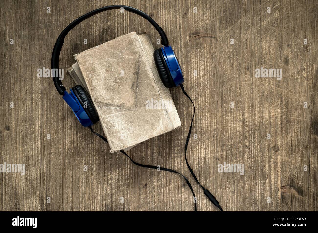 Audio books concept. Headphones put over book with empty cover on ...