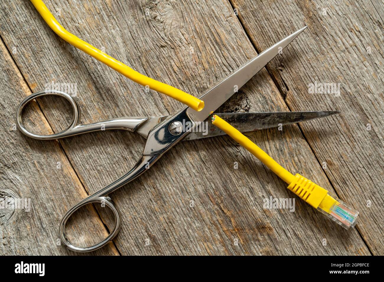 Steel scissors cut the yellow network cable connector.Disconnect from ...