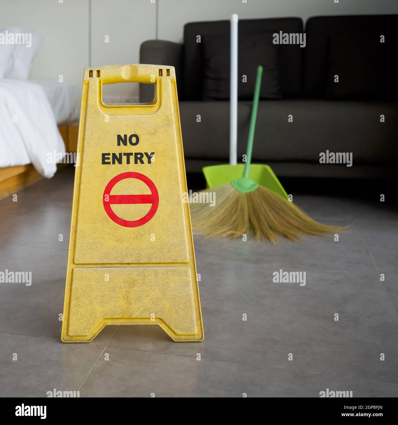 A yellow "NO ENTRY" sign place on the floor in hotel room. While ...