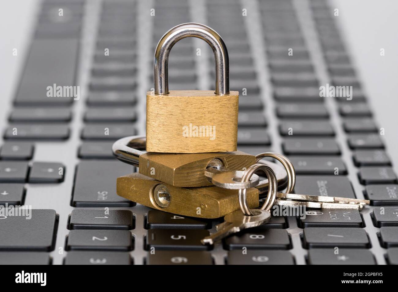 Computer security concept with a three golden padlocks on the keyboard ...