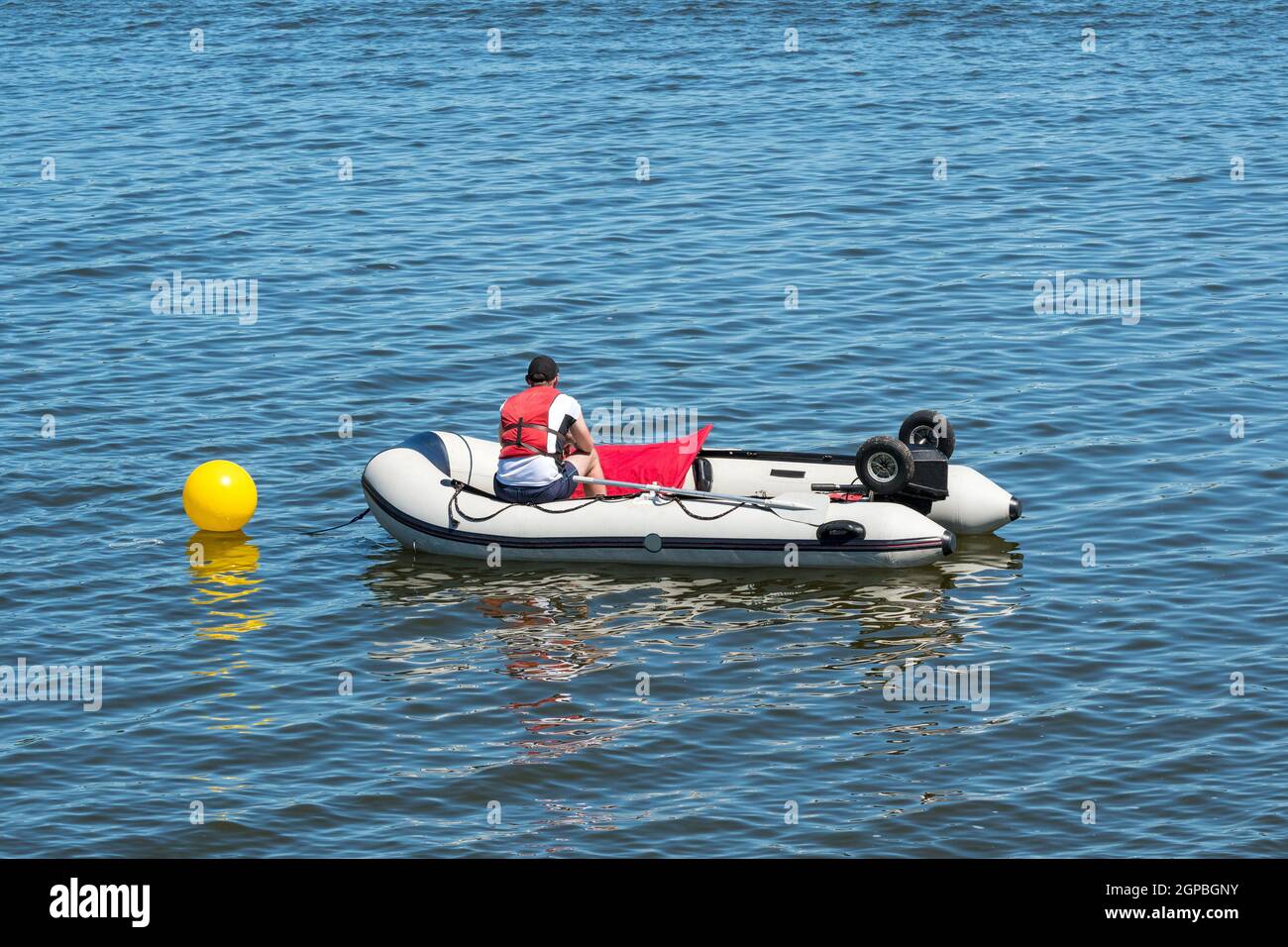 Lifeguard in an inflatable rescue boat patrolling in the lake. View ...