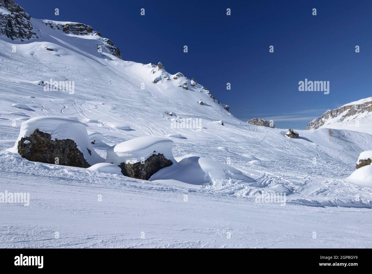 bright snow forms smooth waves on stones in slope in Dolomites, shot ...