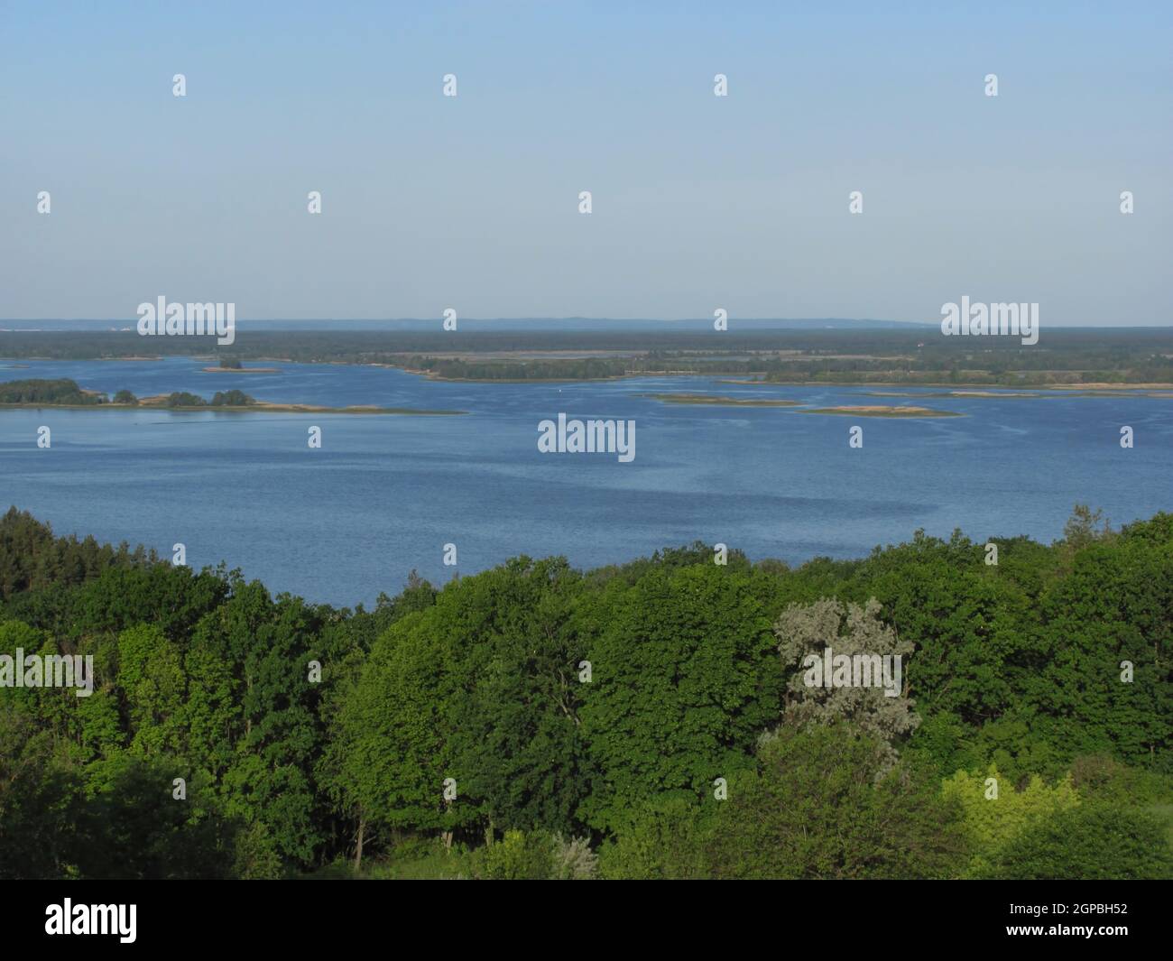 landscape background: green forest, river with islands and blue sky ...