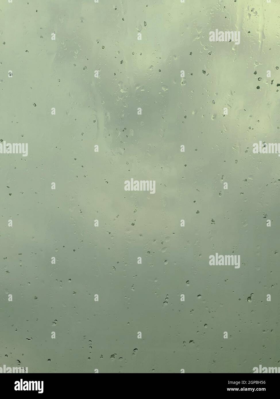 Raindrops on the window during stormy and rainy weather. View of dark ...