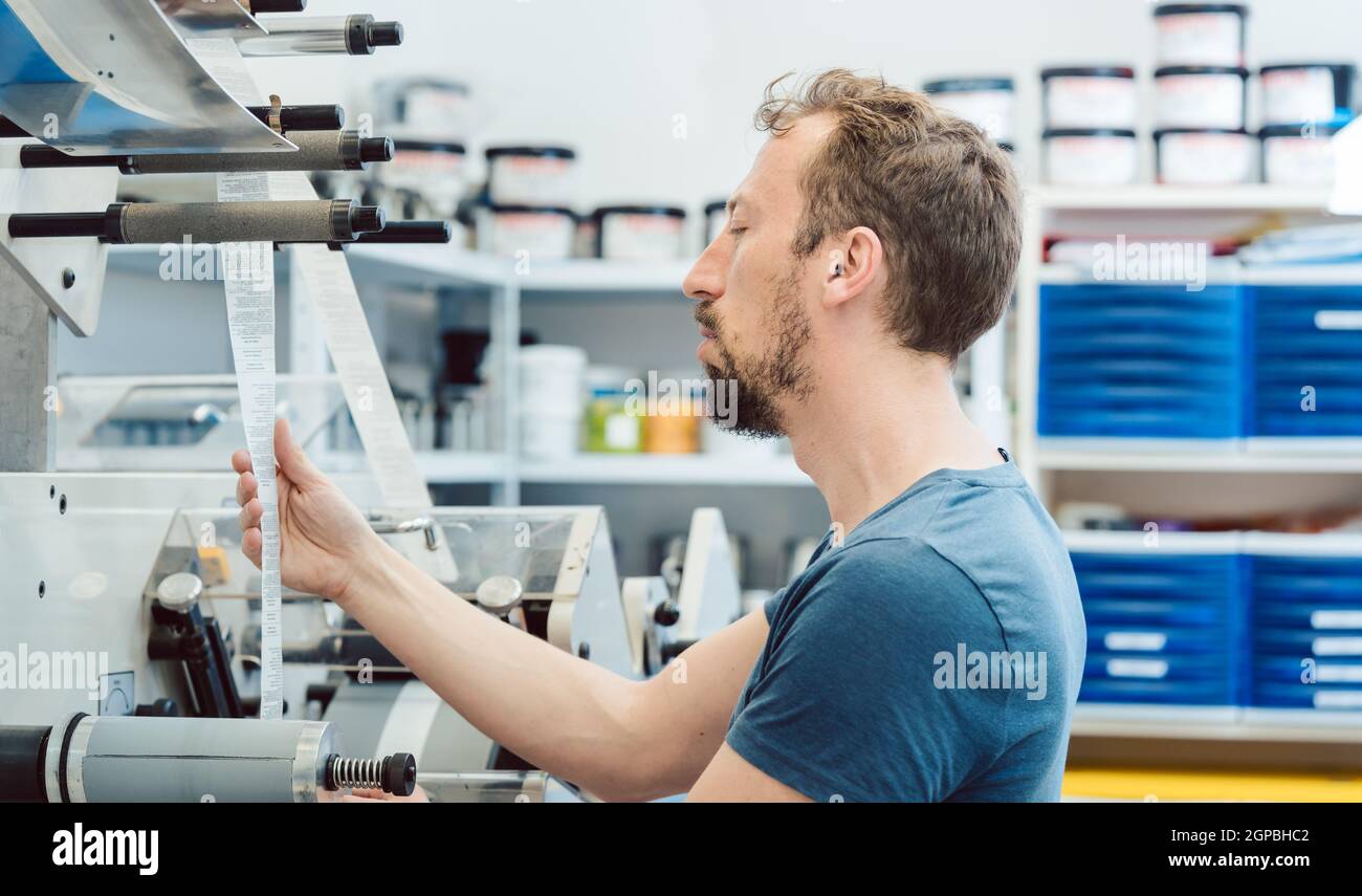 Man checking quality of labels in printing shop carefully Stock Photo ...