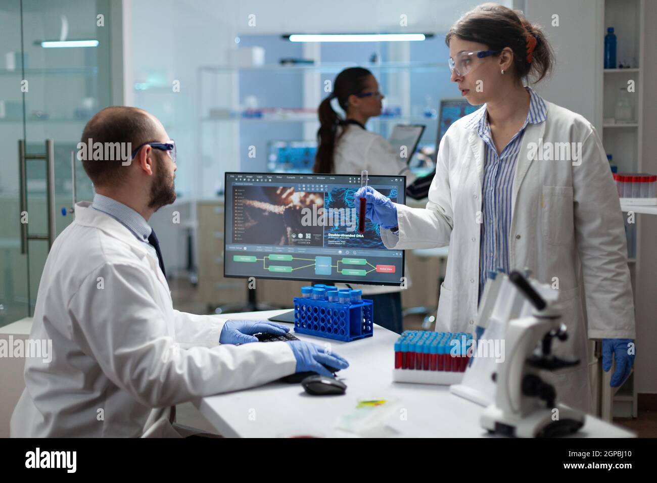 Medical team examining blood sample discussing virus expertise during ...