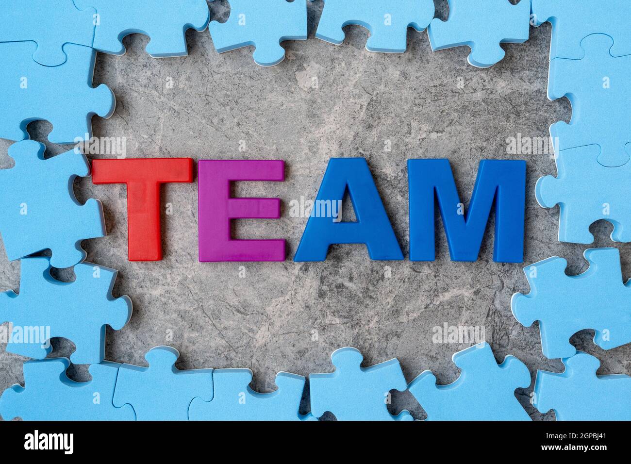 Word TEAM in a middle of jigsaw puzzle frame.Business concept, teamwork ...