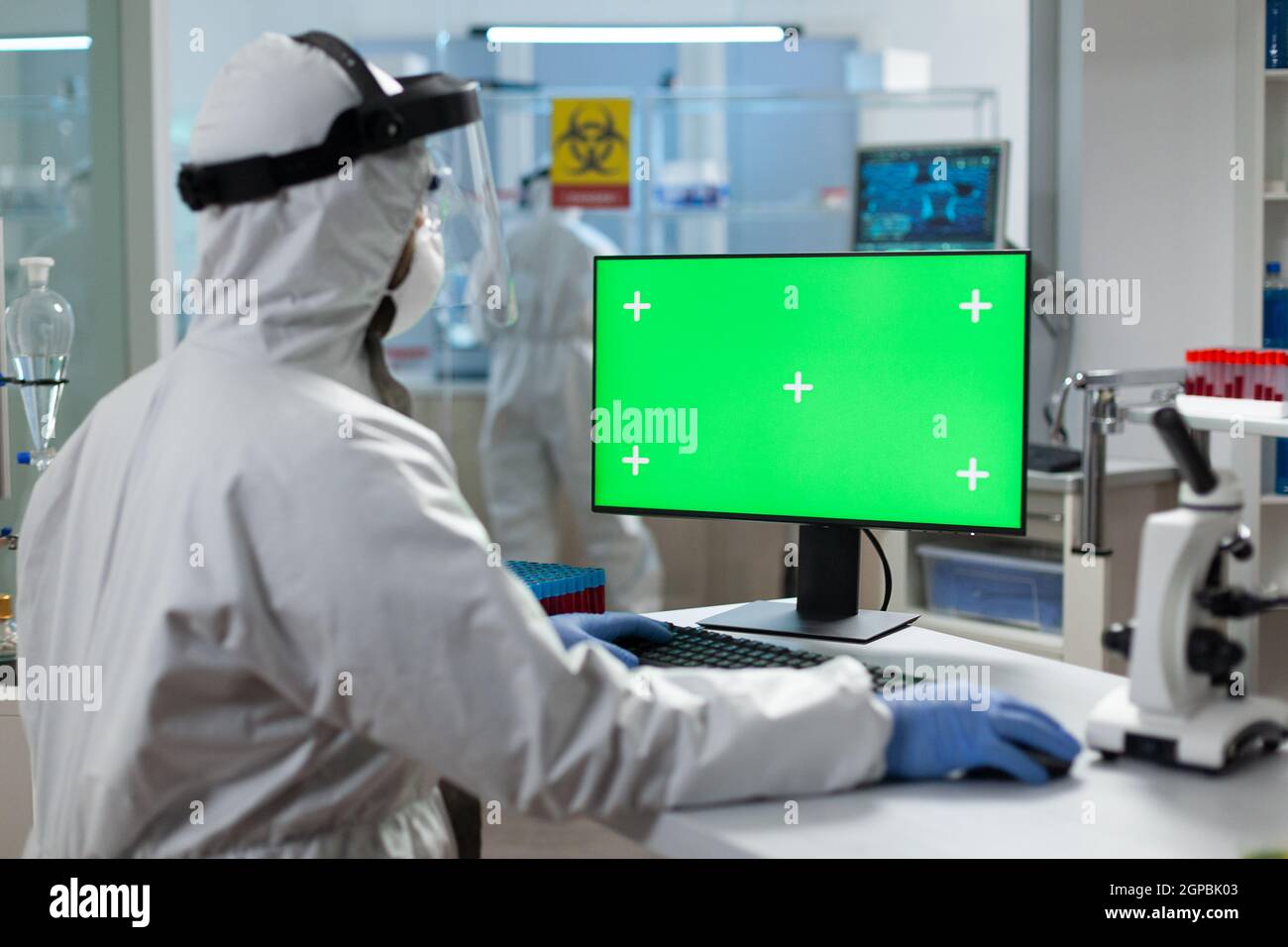 Biologist man with protection ppe medical suit looking at mock up green ...