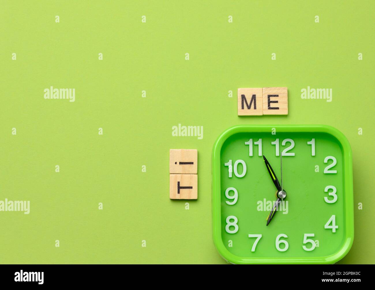 square green alarm clock on a green background and the inscription time ...