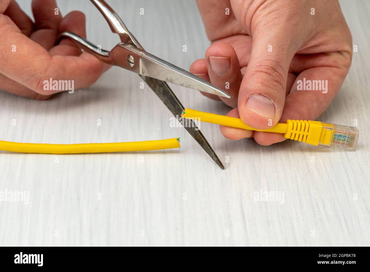 Internet censor cutting a yellow network cable with scissors.Restricted ...