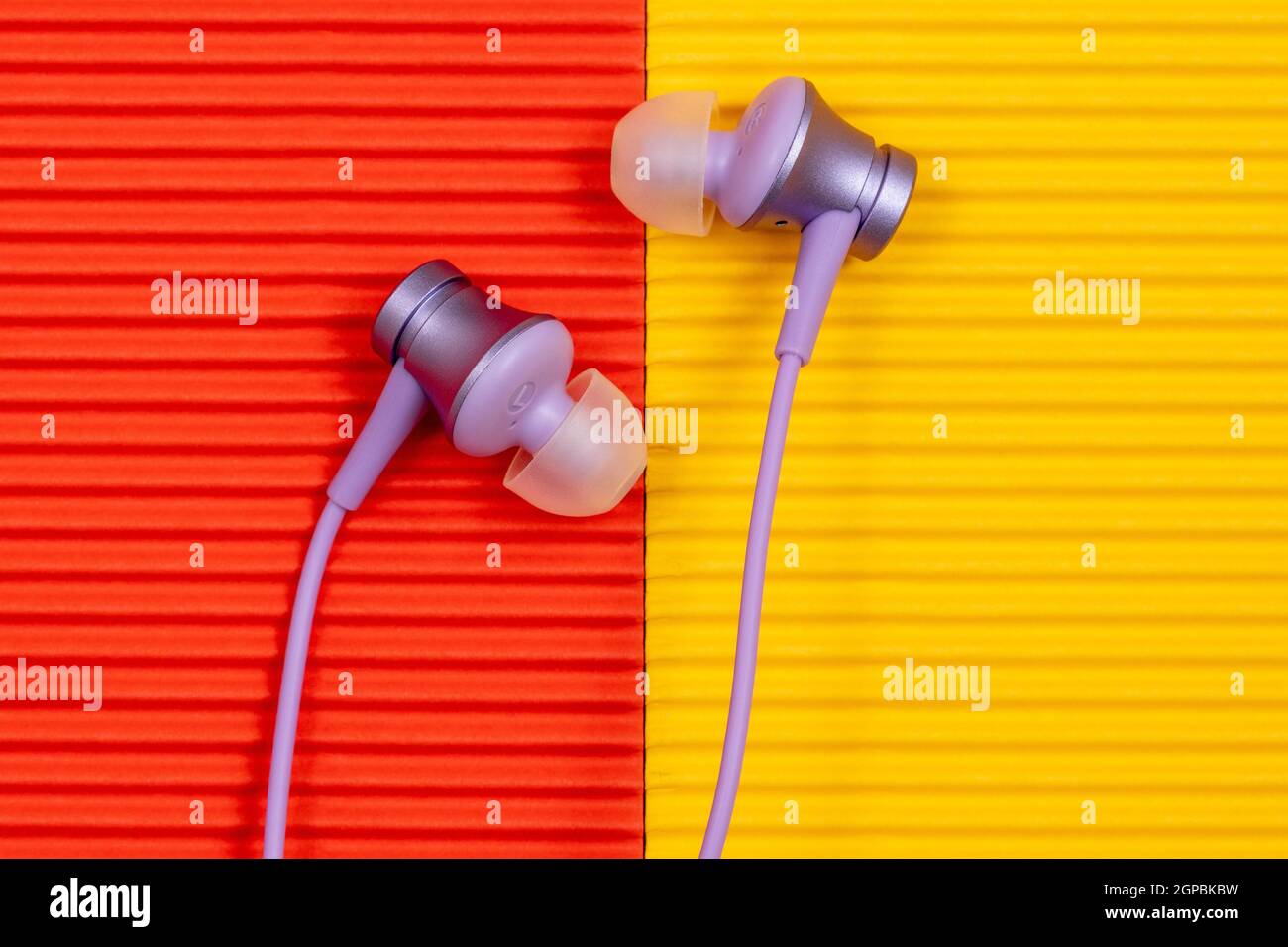 Purple audio earphones on the colorful paper background Stock Photo - Alamy