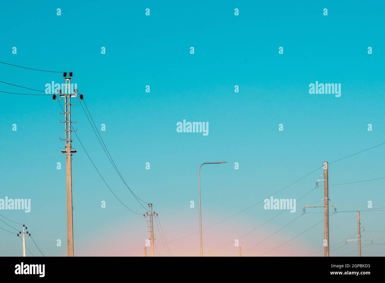Many electrical poles and cables on the sunrise Stock Photo - Alamy