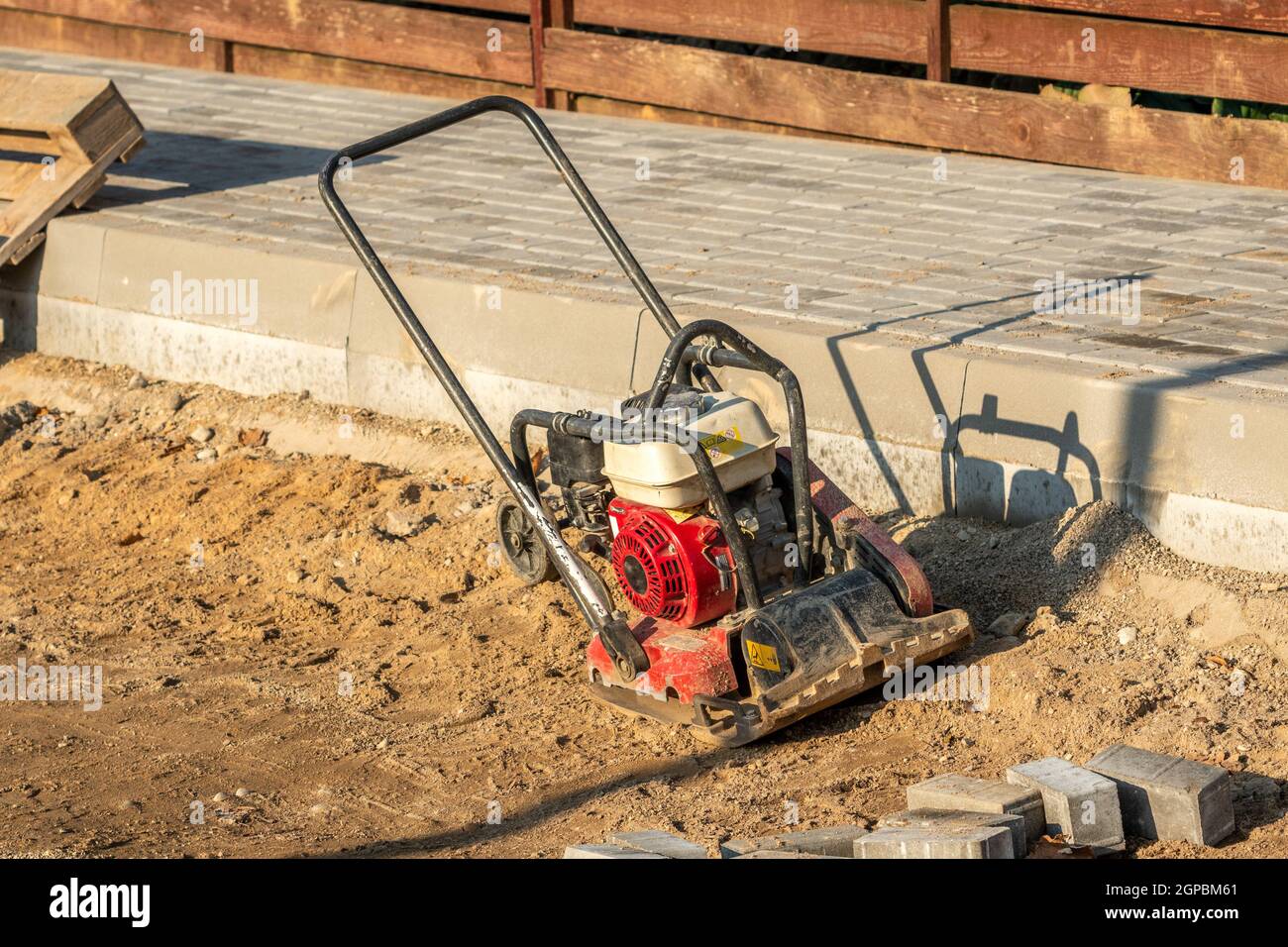 Vibratory plate compactor on road works, repair of road and sidewalk ...