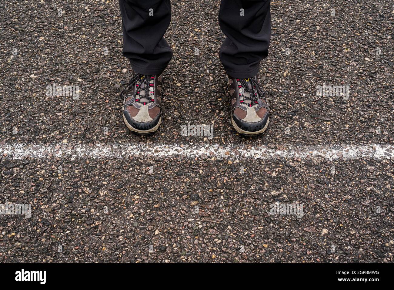 Man standing against white line on a road. New start, new life concept ...