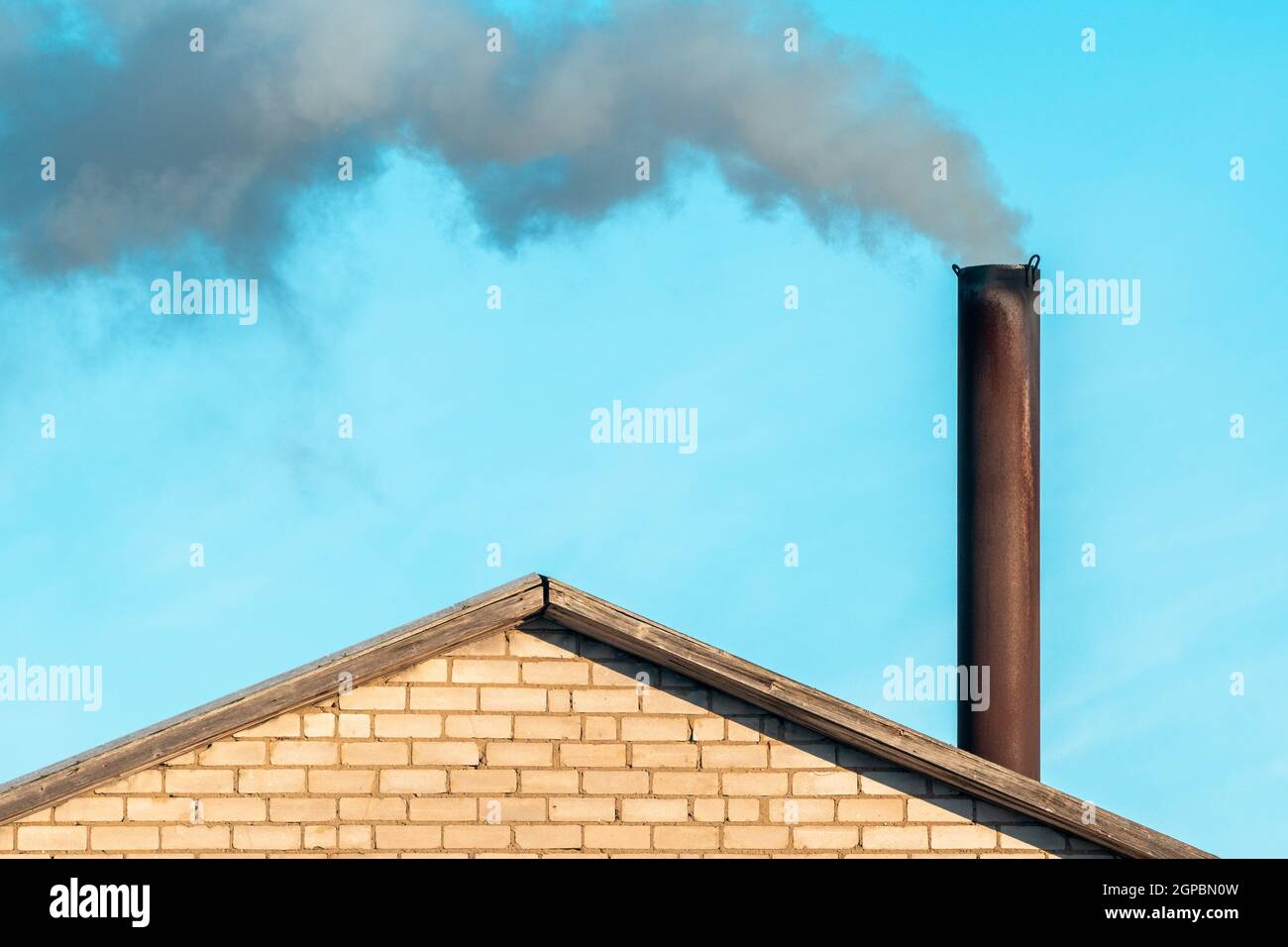 Smoke comes from the chimney of the house. Smoking chimney smoke pollution Stock Photo - Alamy