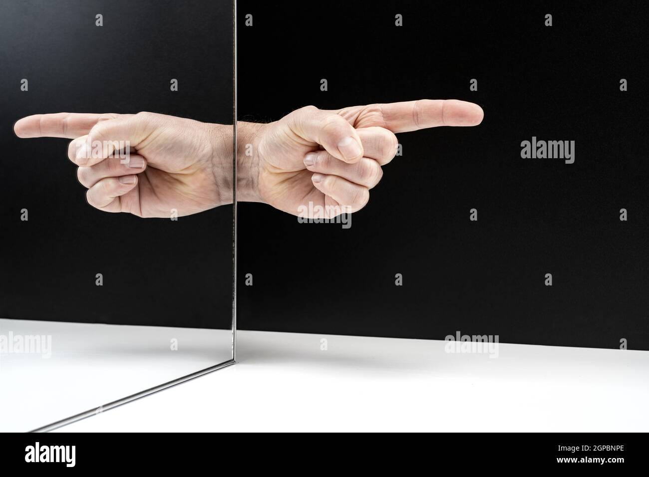 hand from behind the mirror pointing with finger Stock Photo - Alamy