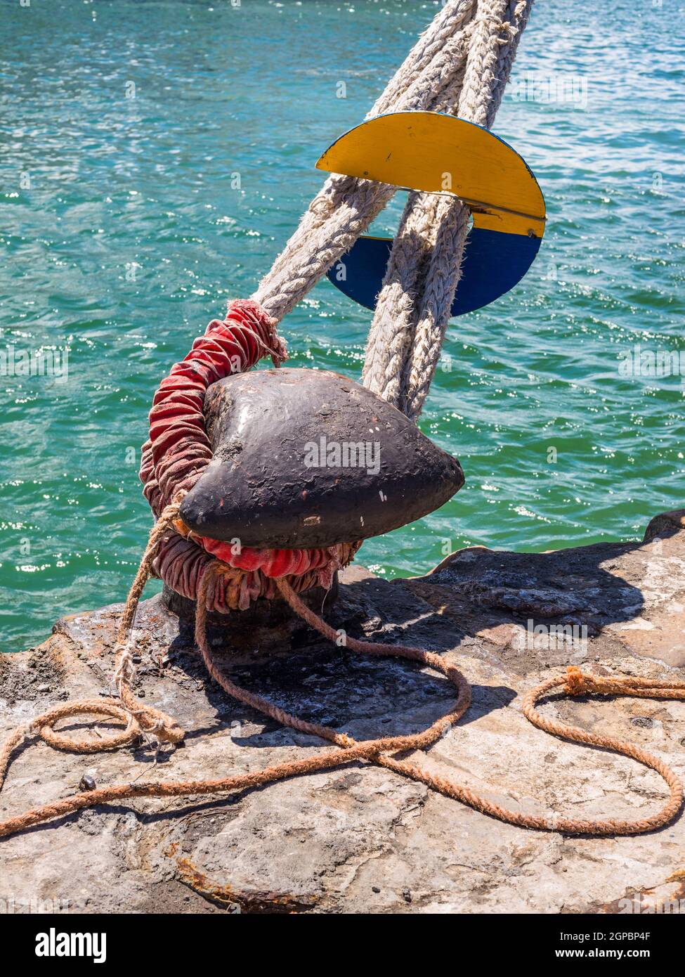 Mooring bollard and cables with rat guards are tied to a bollard to ...