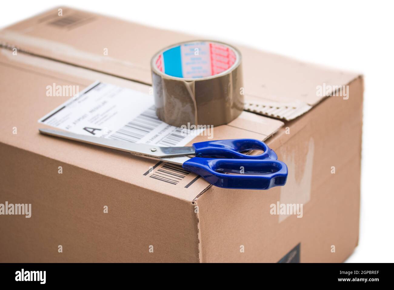 Shipping concept: Cardboard box, scissors and sticky tape Stock Photo ...