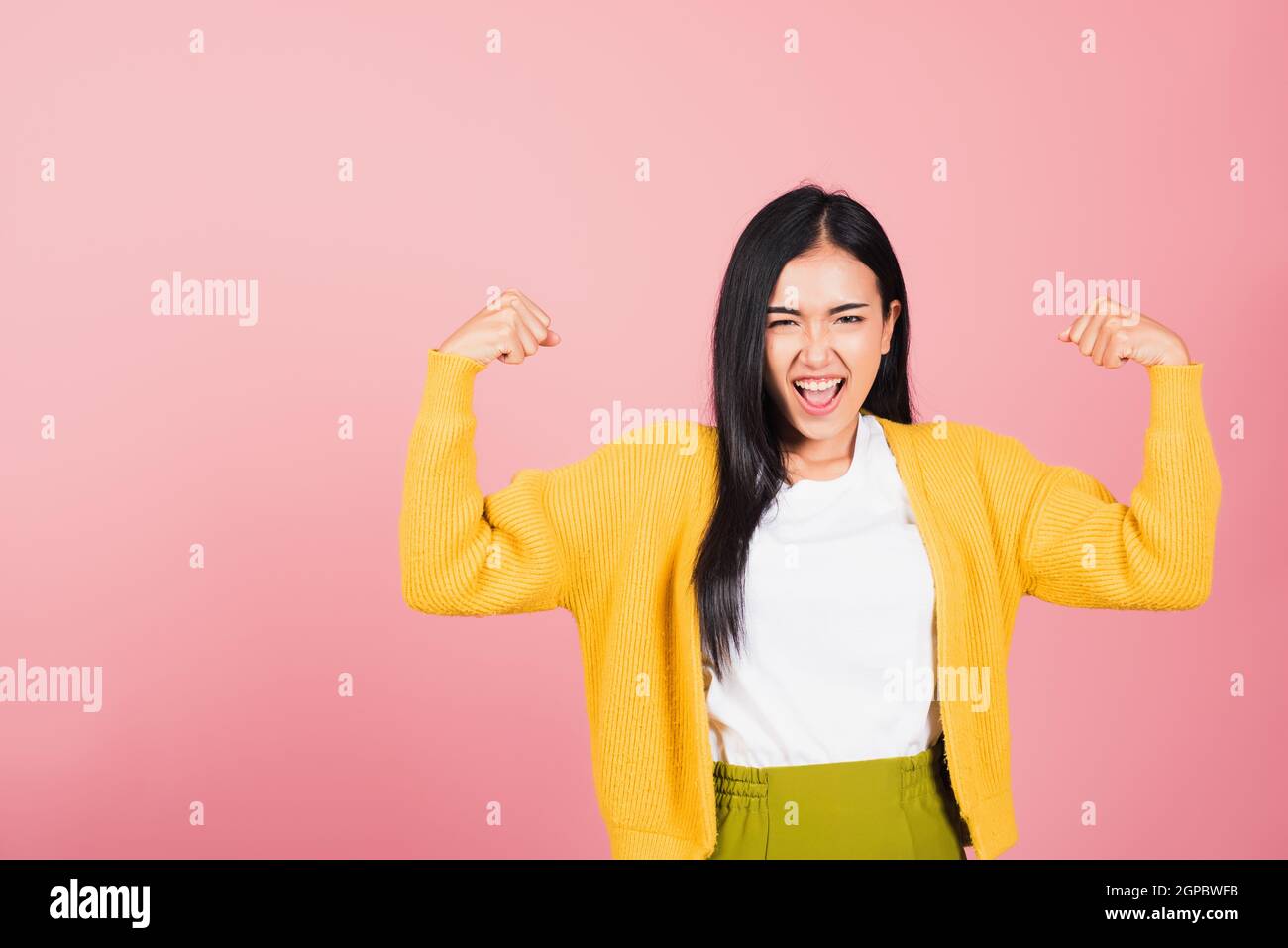 Portrait Asian of happy beautiful strong muscles young woman raises ...