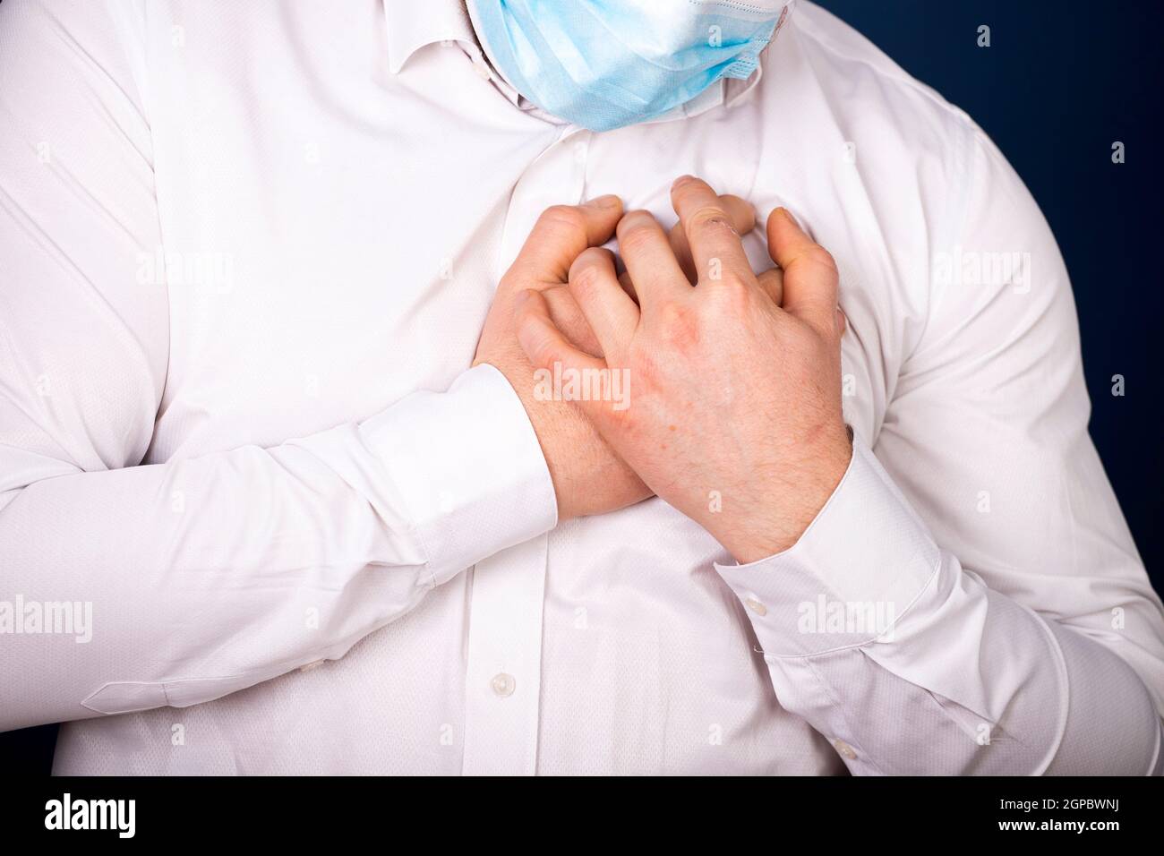 Man wearing medical face mask with chest pain - heart attack, shortness ...